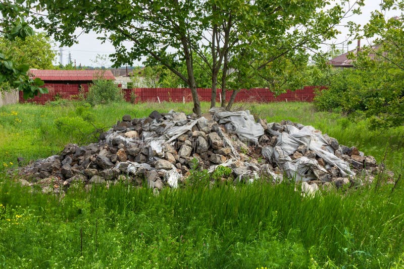 A Pile of Large Stones Lying on Green Grass. Abandoned Building ...