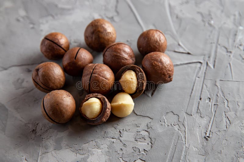 Pile of Macadamia Nuts in Whole Kernels and Half Opened on Wooden ...