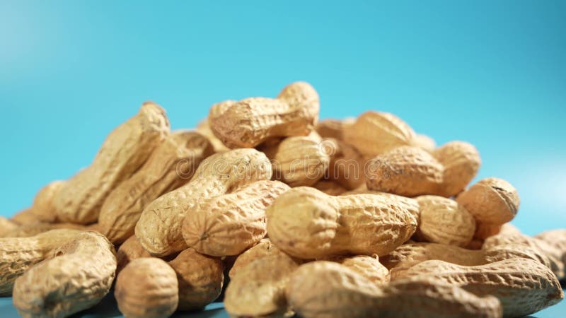 A Pile of Peanuts Rotates on a Blue Surface Stock Video - Video of heap ...