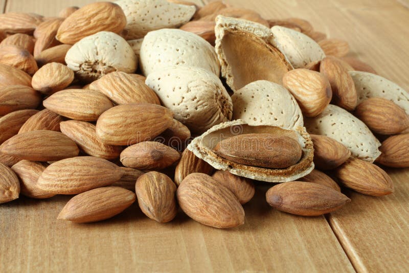 Pile of Peeled Raw Almonds and Raw Almonds with Shells on Wooden Table ...