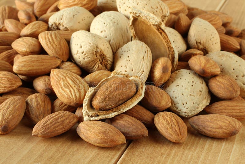 Pile of Peeled Raw Almonds and Raw Almonds with Shells on Wooden Table ...