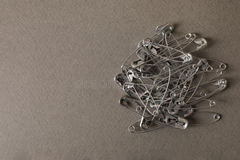 Pile of Safety Pins on Grey Textured Background, Flat Lay. Space for ...
