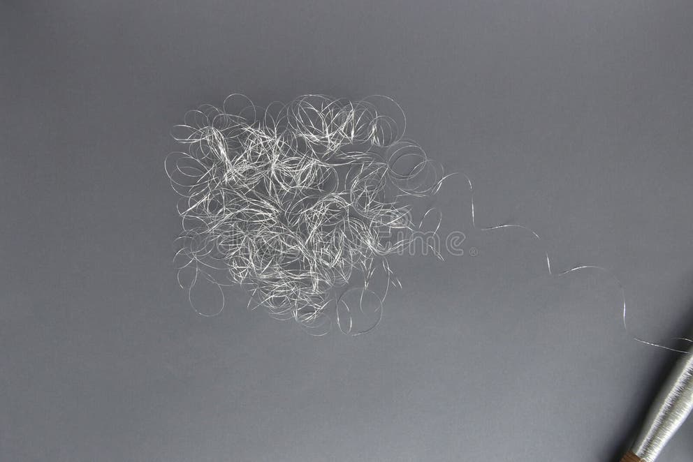 Silver Thread Pile Like Cloud and Spool of Silver Thread. Stock Photo ...
