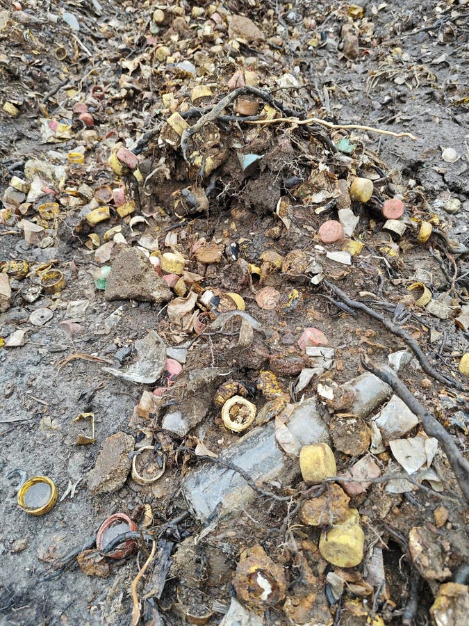 Pile of Thrown Way Rusted and Decayed Bottle Caps on the Muddy Ground ...
