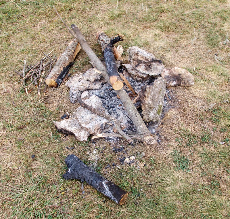 A Pile of Wood and Rocks with a Fire in the Middle Stock Image - Image ...