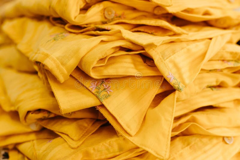 Pile of Yellow Pieces of Fabric with Flowers on Them on the Side Stock ...