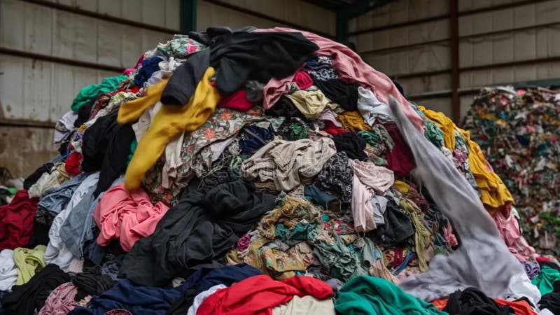 Piles of Colorful Clothes and Textiles in a Recycling or Waste Facility ...