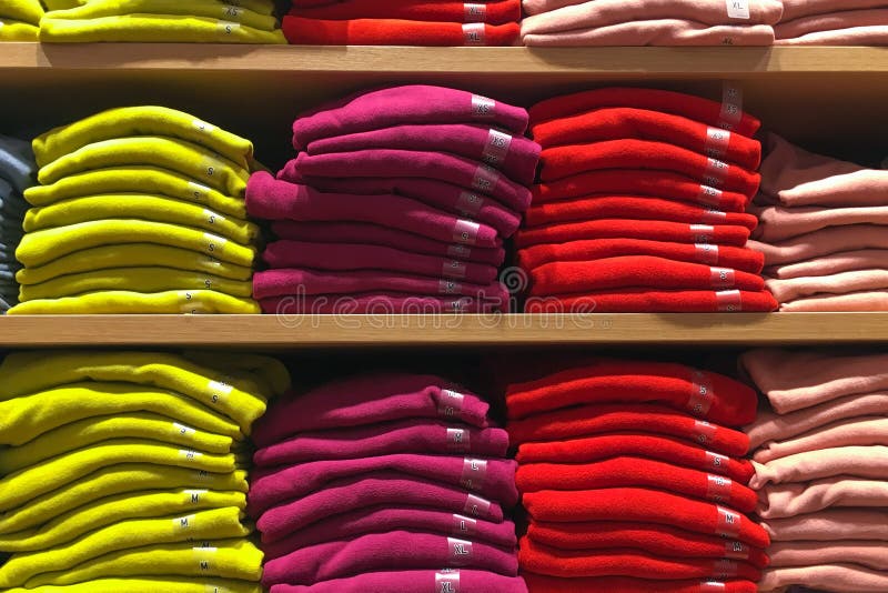 Piles of Multi Colored Clothes on the Shelves in the Store. Stack of ...