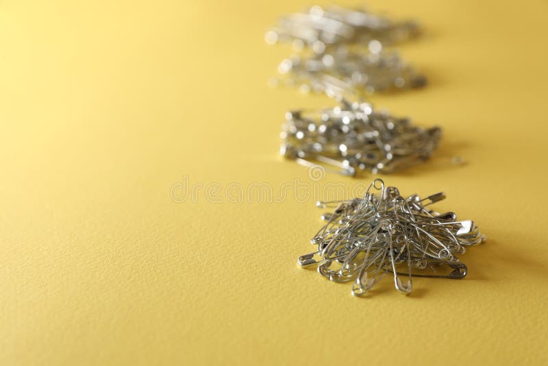 Piles of Safety Pins on Yellow Background, Space for Text Stock Image ...