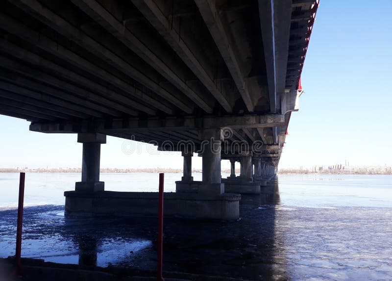 The Pillars of the Concrete Bridge are Frozen into the Ice on the River ...