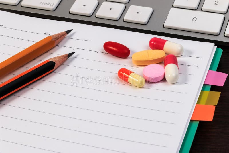 Pills, Capsule, Notebook, Pencils and Computer Keyboard on Wooden Table ...