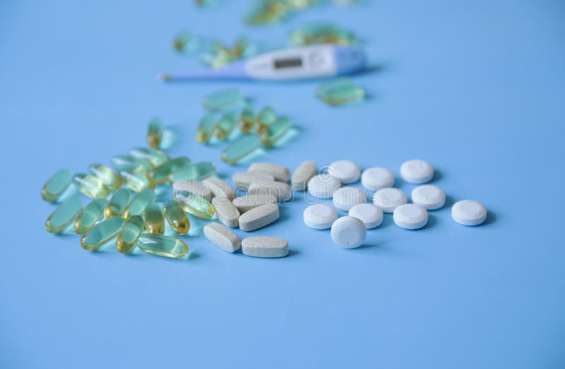 Pills, Capsules and a Thermometer for Measuring Body Temperature on a ...