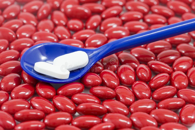Pills in Counting Spoon with Red Pills Background Stock Image - Image ...