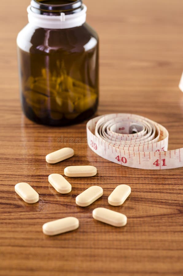 Pills and measuring tape stock photo. Image of bottle - 41179150