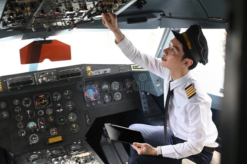 Pilot with Digital Tablet Sitting in Cockpit and Adjusting Controls on ...