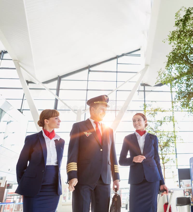 Pilot with Flight Attendants Walking in the Airport Stock Image - Image ...