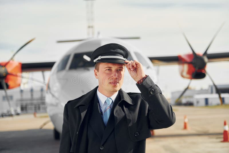 Pilot in Formal Black Uniform is Standing Outdoors Near Plane Stock ...