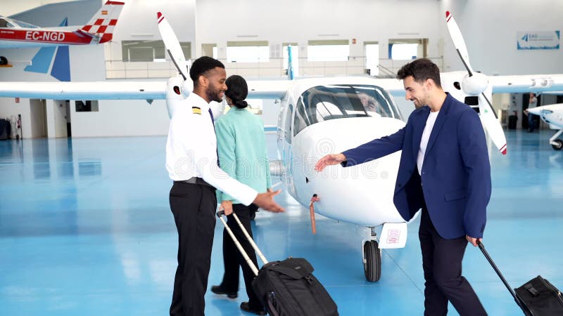 Pilot Greeting Passengers Boarding Private Plane in Hangar Stock ...