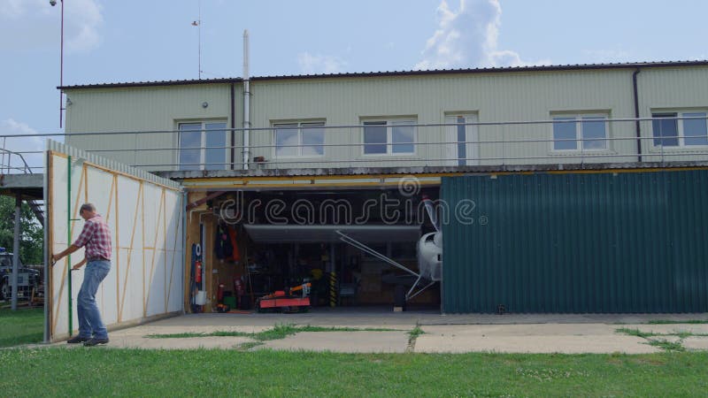 Pilot Opening Gates Hangar with Plane Inside To Start Transportation ...