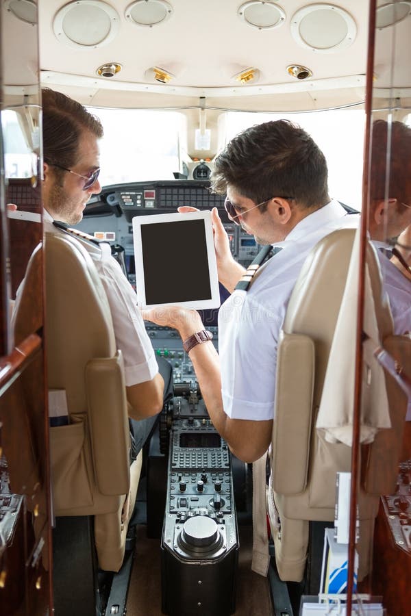 Pilot Showing Digital Tablet To Copilot in Cockpit Stock Photo - Image ...