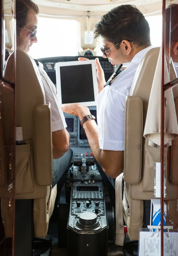 Pilot Showing Digital Tablet To Copilot in Cockpit Stock Photo - Image ...