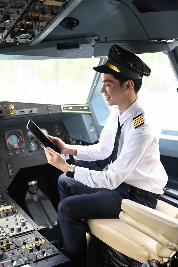 Pilot is Sitting in the Cockpit of an Airplane and Using Digital Tablet ...