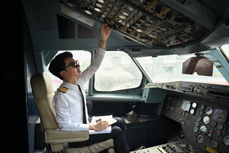 Pilot Sitting Inside the Cockpit of an Airplane, Reaching Up To ...