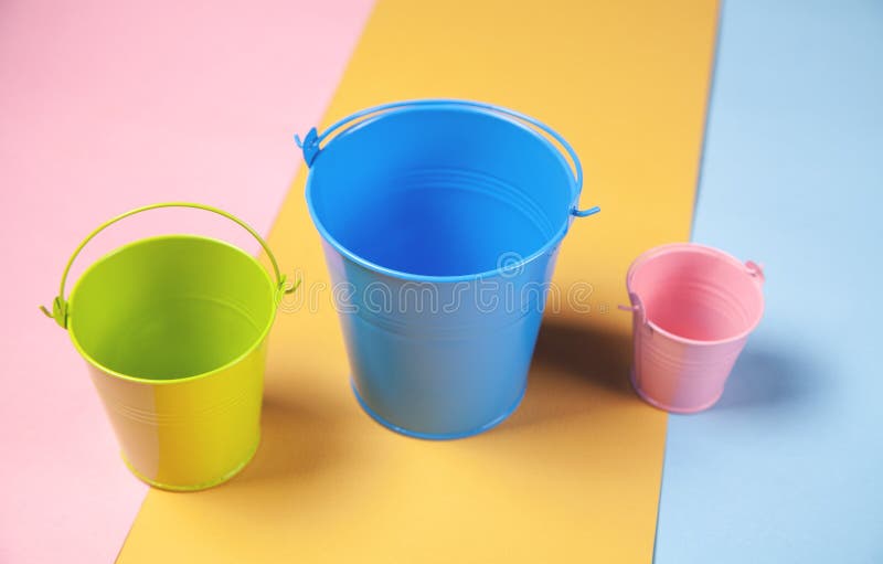 Pink, Blue, Green Bucket on the Color Paper Background Stock Photo ...