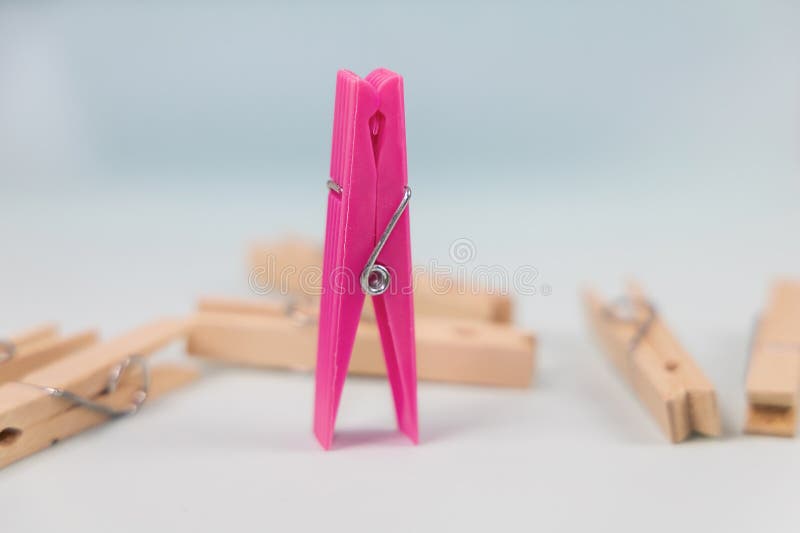 Pink Clothespin On The Background Of Ordinary Wooden Clothespins Stock
