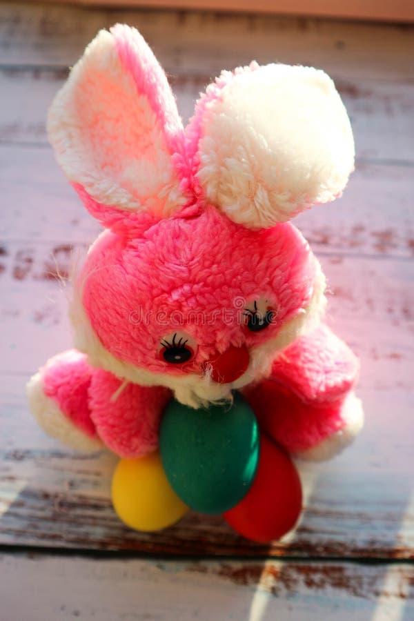 Pink Easter Bunny with Colorful Eggs on Wooden Table Stock Photo ...