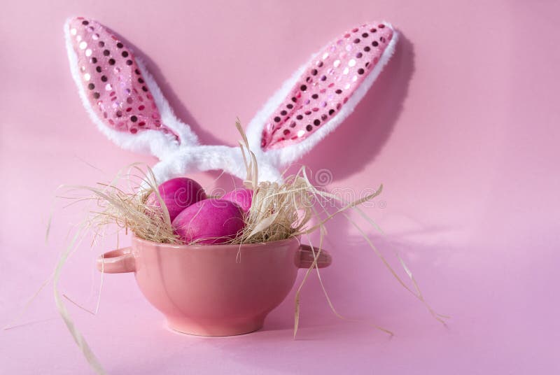 Pink Easter Eggs in Hay in a Plate, Pink Rabbit Ears Stock Image ...