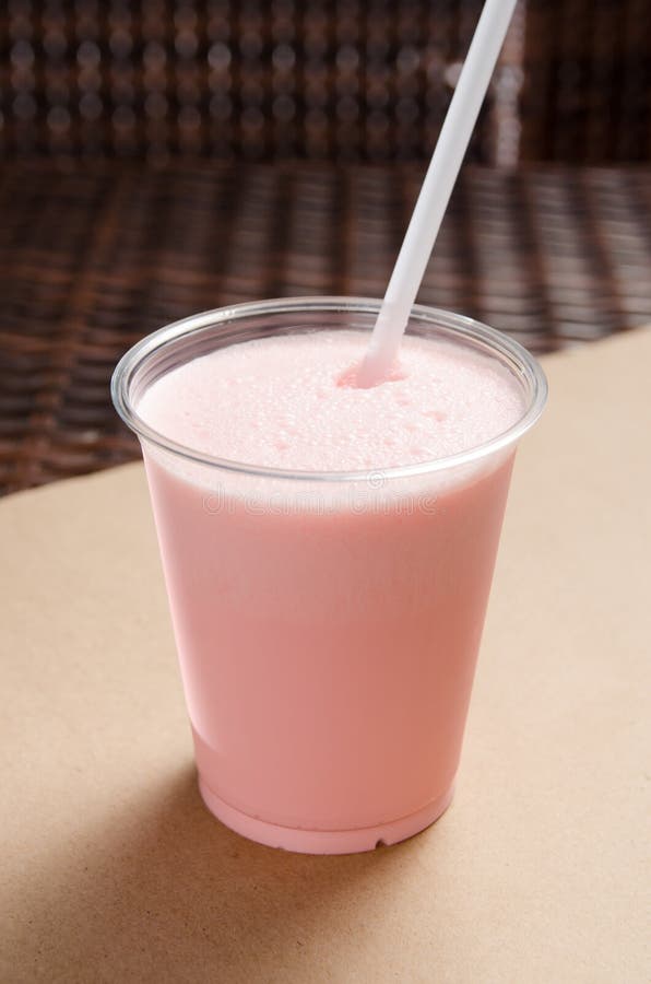 Pink Milkshake with Juice in a Transparent Glass Next To Sweet Colorful ...