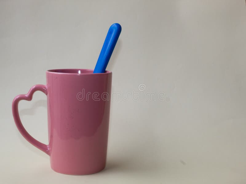 A Pink Mug and a Blue Spoon Stock Photo - Image of violet, color: 202877212