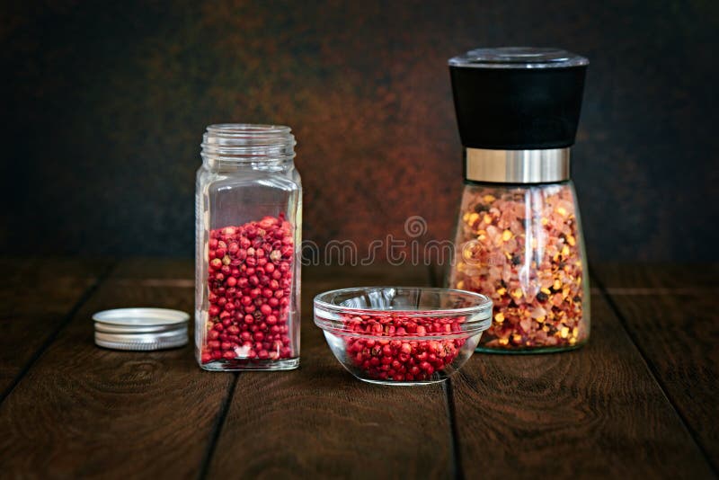 Pink Pepper and a Mixture of Spices in Glass Jars on a Dark Background ...
