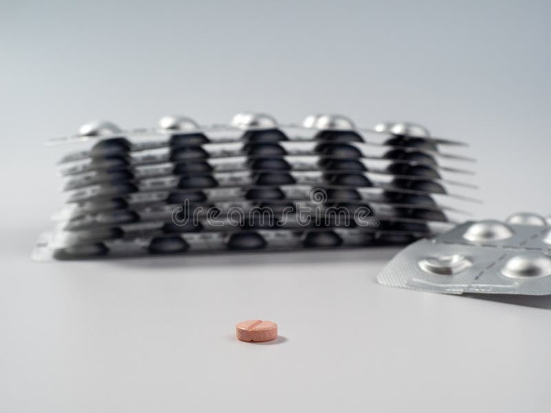 Pink Pill on the Background of Packed Pills. Medicine in Tablets Stock ...