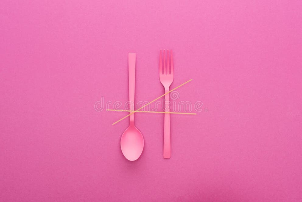 Pink Plastic Spoon Upside Down and Fork with Spaghetti Isolated on Pink ...