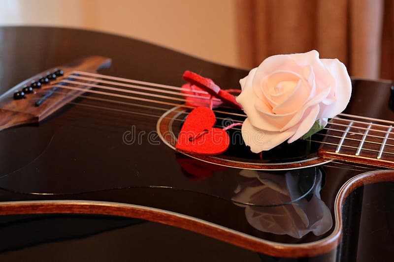 Pink Rose Flower and Red Hearts on the Strings of a Dark Guitar. Stock ...