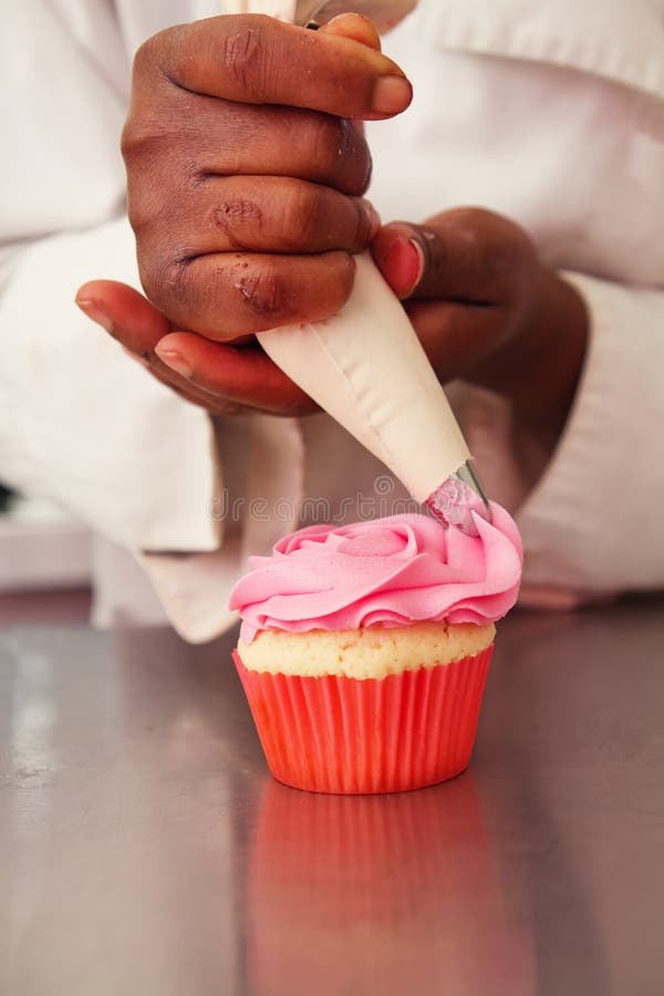 Pink Rose Icing Being Piped Onto a Cupcake Vertical Stock Image - Image ...