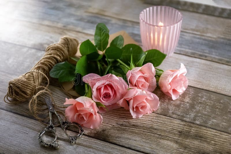 Pink Roses, a Spool of Thread, Scissors and a Candlestick on a Wooden ...
