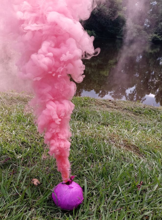 Pink Smoke Bomb by pond stock photo. Image of smoke - 222929990