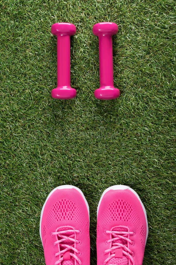 Pink Sneakers Stand in Front of Pink Dumbbells for Training on Green ...