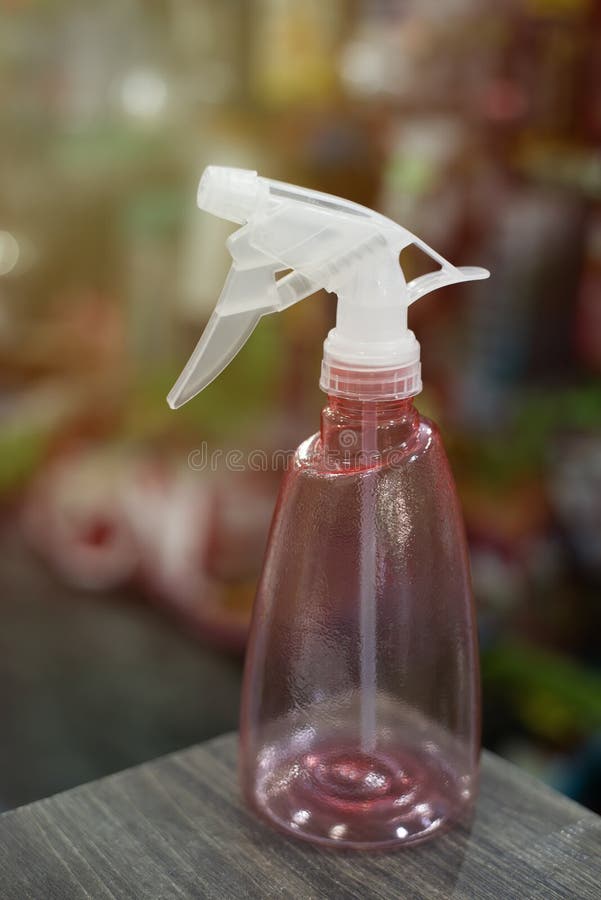 Pink Spray Bottle Placed on a Dark Brown Table Behind is a Shop. There ...