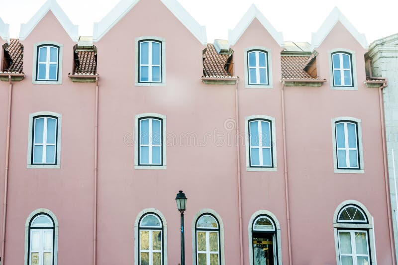 Pink Stucco House with a White Framed Windows and a Lamppost in Front ...