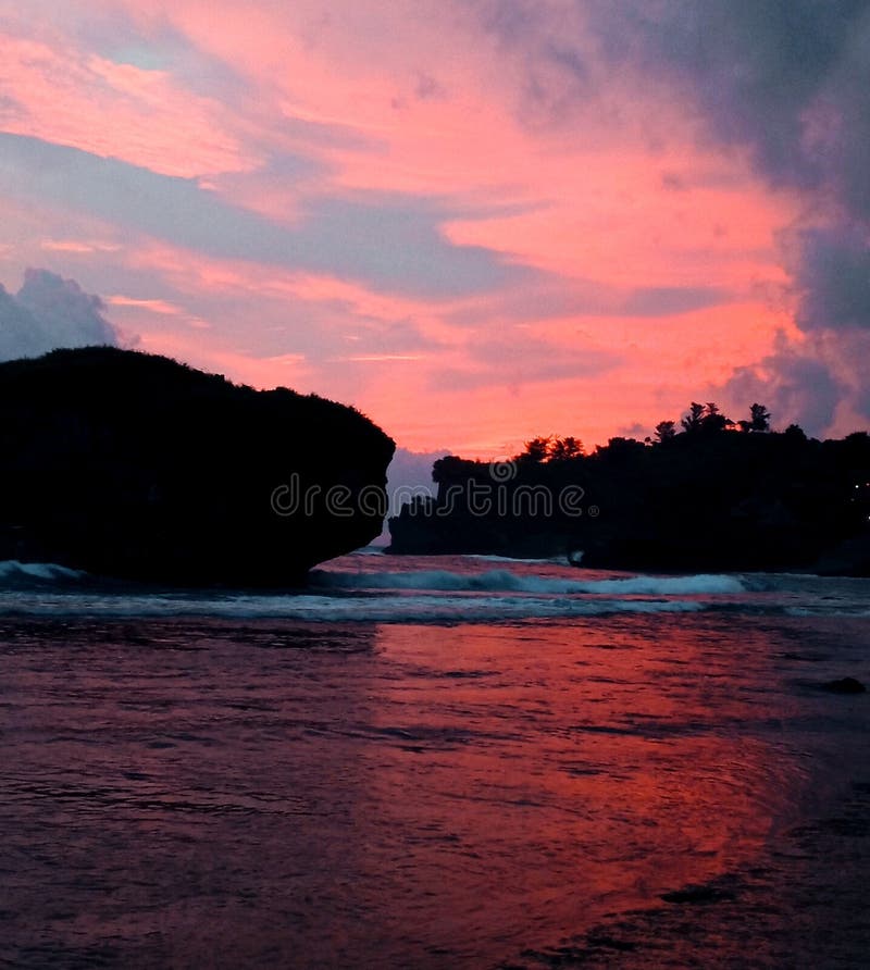 Pink Sunset by the Beach with Views of the Waves Crashing into the ...
