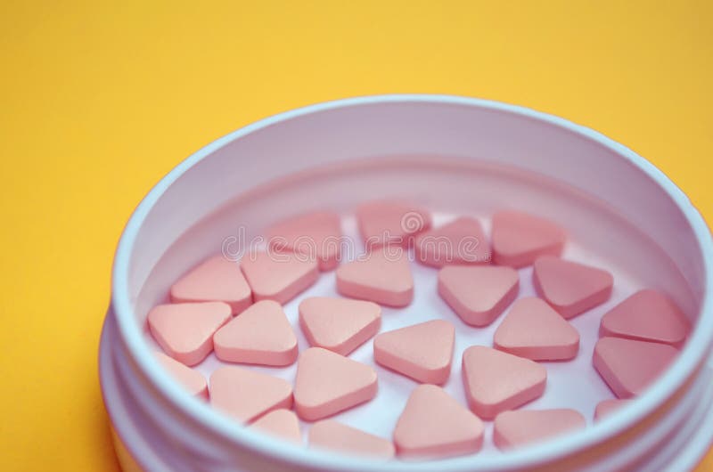 White Triangular Unusual Pills Dispersed on a Pink Background Closeup ...