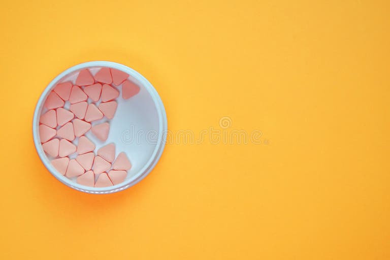 Pink Triangular Unusual Pills in a White Round Box on Yellow Background ...