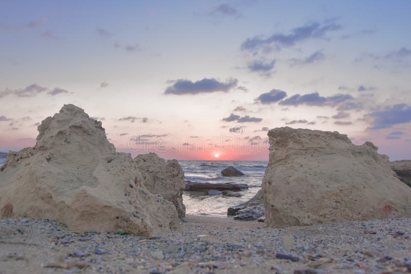 Pinky Sunset between Stones on the Beach Stock Photo - Image of ...