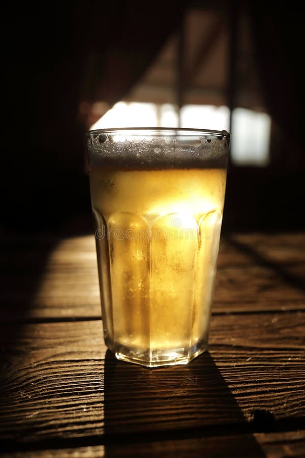 Pint of beer lit by light stock photo. Image of beer - 189146748