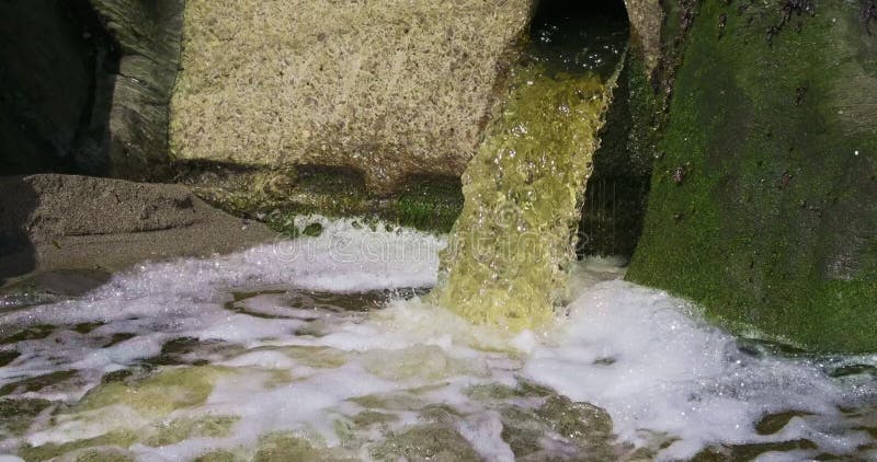 A Pipe in a Rock Wall Discharging Water, Creating a Mini Waterfall ...