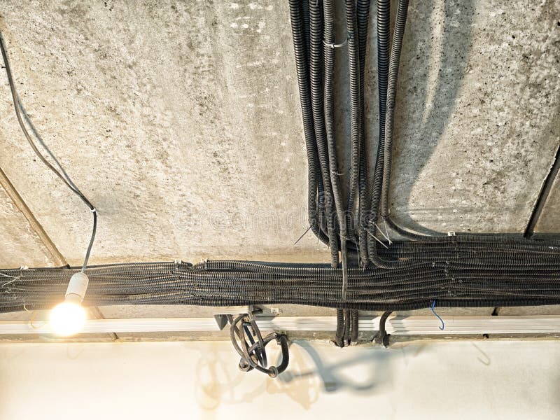 Wires and Pipe Installations Illuminated by a Single Light Bulb in a ...